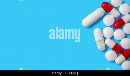 Different shapes and colors of capsules and tablets are spread across a ...