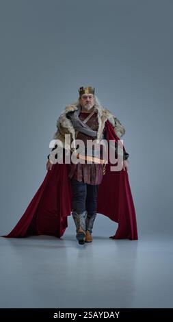 Man, medieval king walks forward with determination, cloak flowing ...