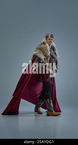 Man, medieval king walks forward with determination, cloak flowing ...