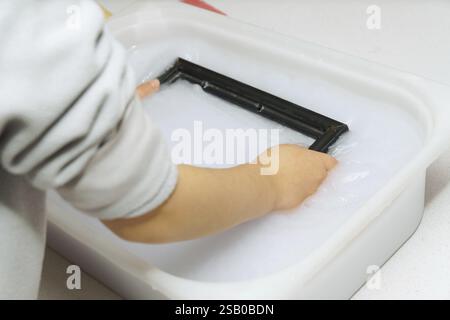 Close-up of kid's hands makes holiday decorations, attaches colorful ...