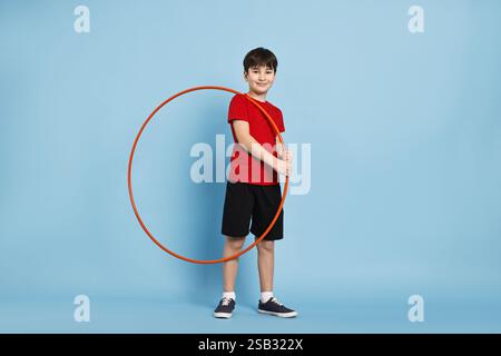 Boy with hula hoop on light blue background Stock Photo - Alamy