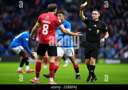 Referee Steven McLean shows a yellow card to Rangers' Dujon Sterling ...