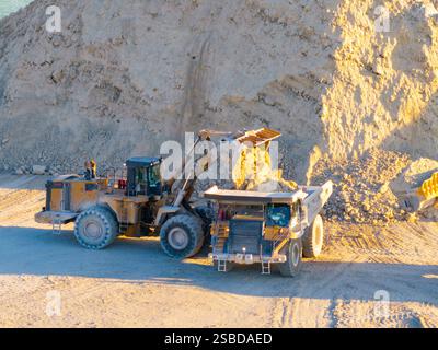 Wheel loaders loading rock into a dump truck at a quarry Stock Photo ...