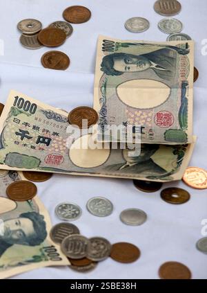 Japanese coins and banknotes tossed into an offertory box at a shrine ...