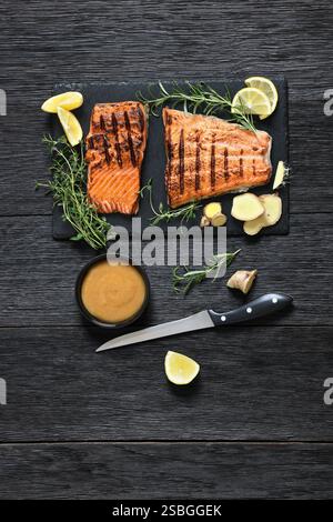 Grilled salmon fillet with charred lemon and greens on plate Stock ...