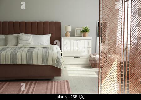 Bed in mocha mousse shade indoors. Cozy bedroom interior with trendy ...