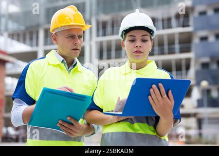 Two builders planning their work in construction plant Stock Photo - Alamy