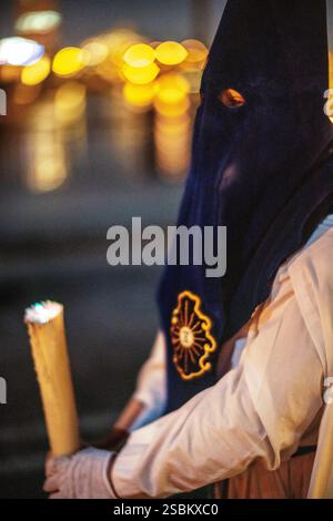 A nighttime procession featuring penitents with traditional outfits ...