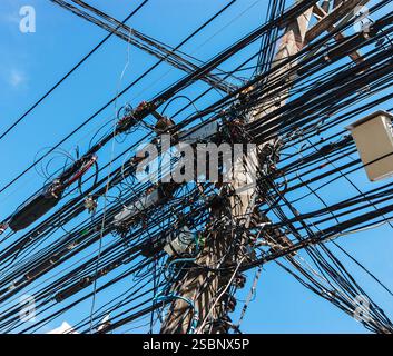 Intertwining of many electrical wires on poles Stock Photo - Alamy