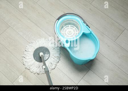 String mop and bucket with detergent on wooden floor, top view Stock ...