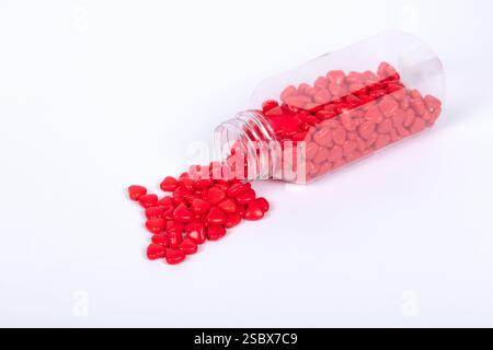 Red heart shaped pills with plastic bottle on blue background.Concept ...