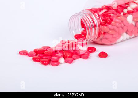 Red heart shaped pills with plastic bottle on blue background.Concept ...