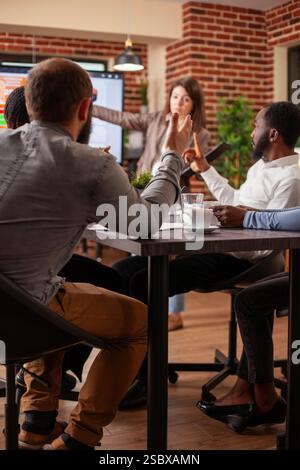 Presenting charts on screen colleague guiding discussion in office ...