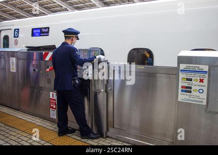 Station staff on the platform of the Shinkansen train at Shin-Osaka ...