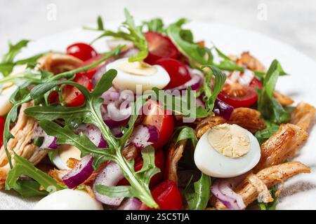 Roasted quail presented on white plate, surrounded by fresh cherry ...