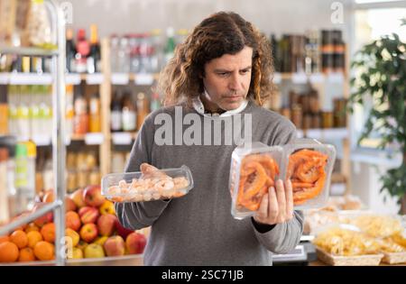 Adult man chooses prawns in grocery store Stock Photo - Alamy