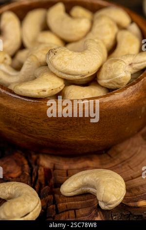 cashew nuts are scattered on a larch board, raw unroasted cashew nuts ...