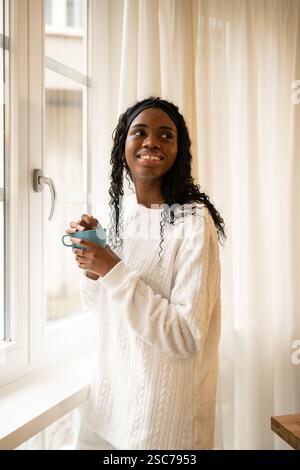 Young woman wearing homewear holding jack russell terrier dog near his ...