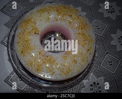 Close-up corn cake, shiny. Cake sits on a black plate, set against a ...