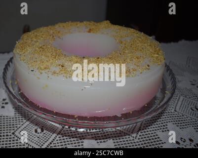 Close-up corn cake, shiny. Cake sits on a black plate, set against a ...
