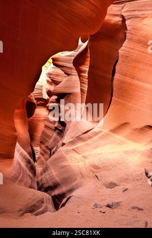 A canyon with a red wall and a small opening. The canyon is in the ...