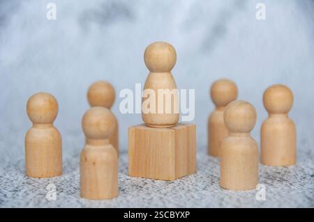 Wooden figure doll representing a leader. Surrounded by followers ...