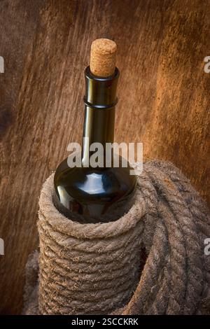 bottle of wine wrapped with rope on the background of the old wooden ...