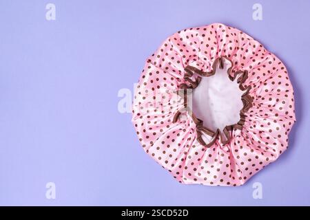 One shower cap on lilac background, top view. Space for text Stock ...
