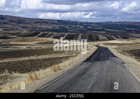 Route surrounded by fields and hills on a cloudy day Stock Photo - Alamy
