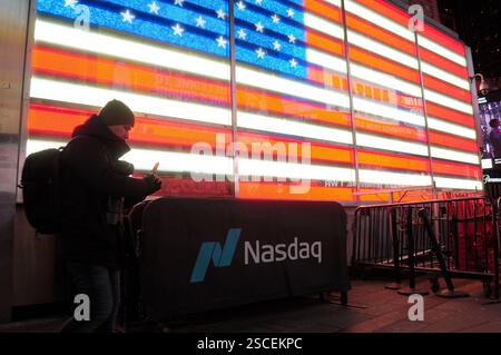 People walk past a Nasdaq sign below a lighting installation of the ...