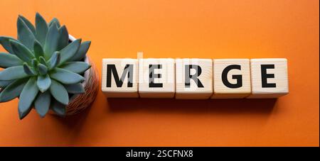 Merge symbol. Wooden cubes with word Merge. Beautiful orange background ...