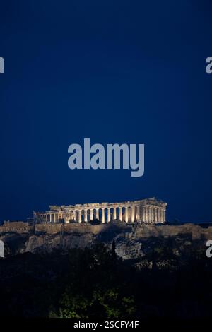 Acropolis lighted at night at the blue hour from down in the city of ...
