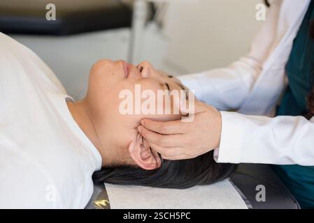Doctor doing a cranial adjustment on patient Stock Photo - Alamy