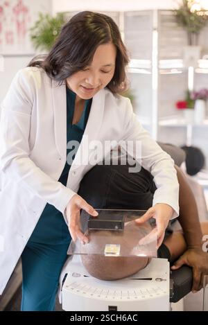 Female asian adult using laser equipment for male patient treatment in ...