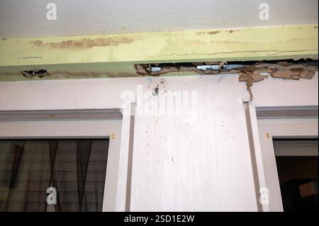 Wet and partially pried open ceiling wall in an apartment, with water ...