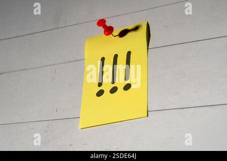 Sticky note with exclamation mark pinned on board Stock Photo - Alamy