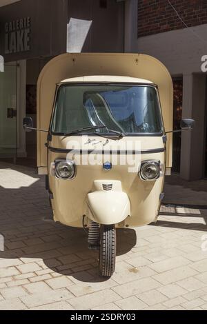 The typical Italian three-wheeler car, Piaggio Ape, driving uphill in ...