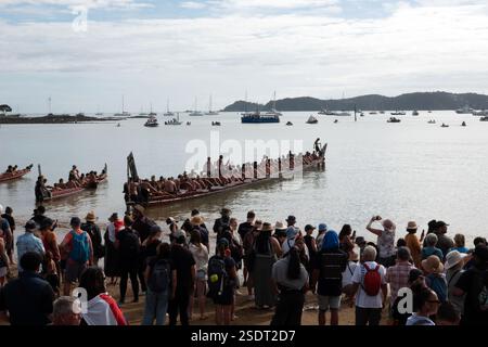 Traditional Maori waka canoe leaving the beach during Waitangi Day ...