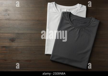 Different t-shirts on wooden background Stock Photo - Alamy