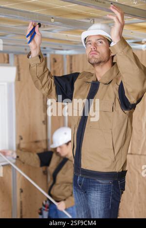 builder using tool to fix ceiling indoors Stock Photo - Alamy