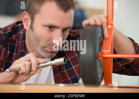 handyman using a spanner to assemble a trolley Stock Photo - Alamy