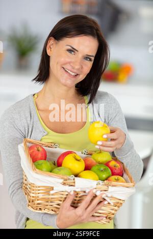 wicker basket with fresh apples and lettuce in the garden, close-up ...