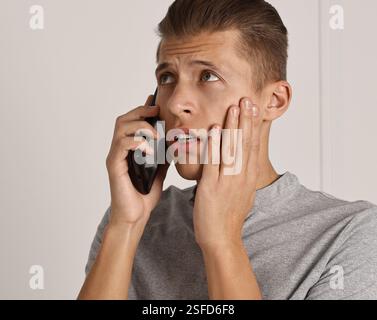 Stressed man calling hotline for mental health help indoors Stock Photo ...