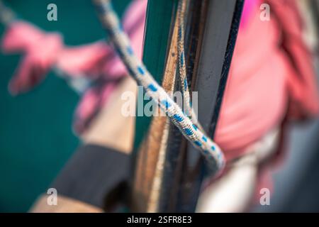 A close-up view of a securely tied rope and knot on a ship mast ...