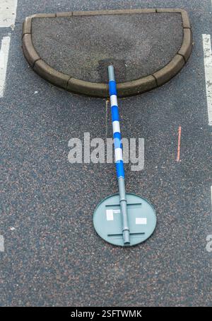 road with white lane markings and fallen blue and white striped pole ...