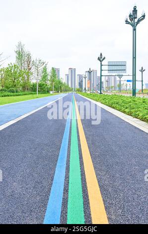 A bicycle lane with three lines: blue, green and yellow Stock Photo - Alamy