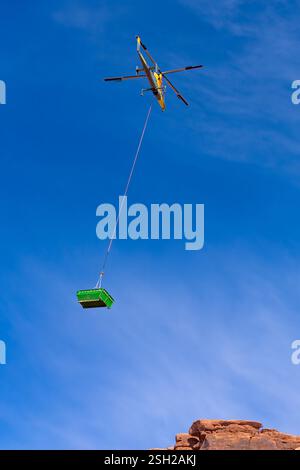 A Kaman K-1200 K-MAX heavy lift helicopter removing debris on a ...