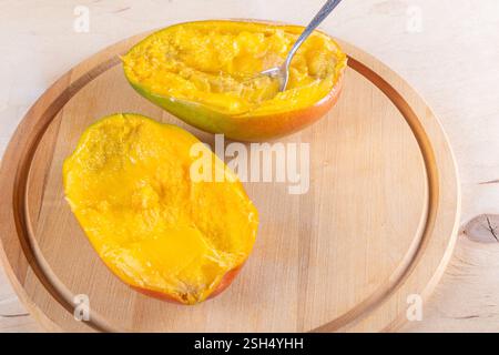 Two halves of mango on light beige wooden background with negative ...