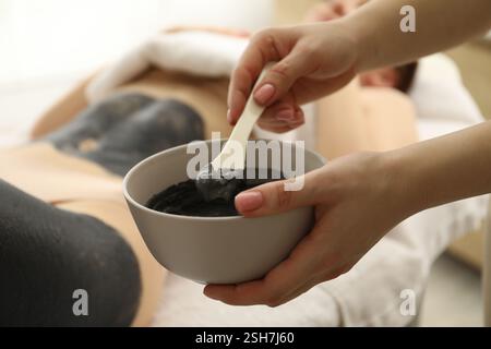 Esthetician applying cosmetic product for body wraps treatment onto ...
