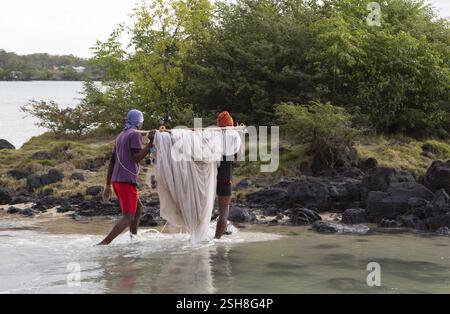 Mauritian men fishing with a traditional net in the Indian Ocean near ...